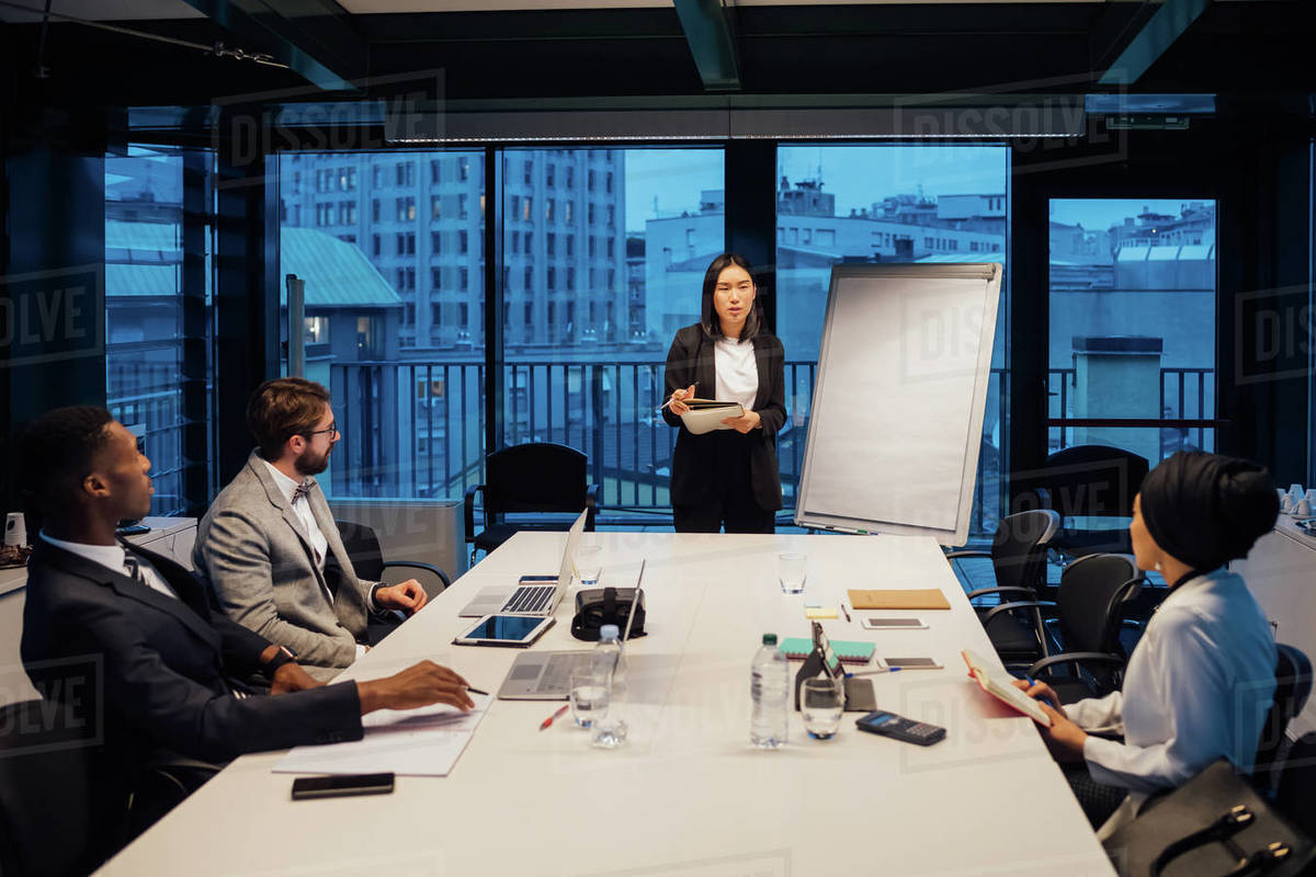Businesswoman making presentation to team during meeting - Royalty-free ...