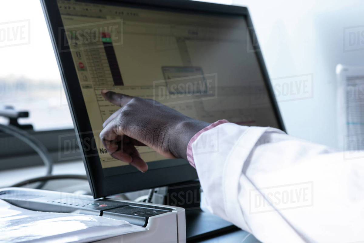 Young female scientist pointing at computer screen in laboratory ...
