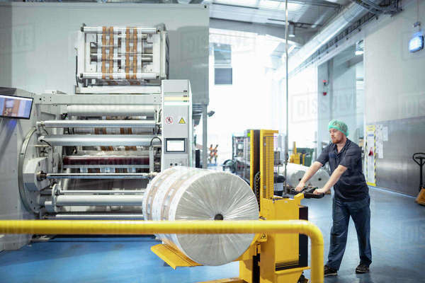 Worker with food packaging printing machine in print factory - Stock ...