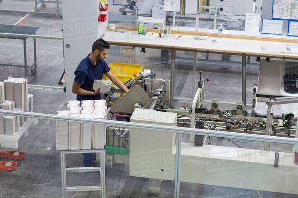 Male worker using machine in paper packaging factory - Royalty-free ...