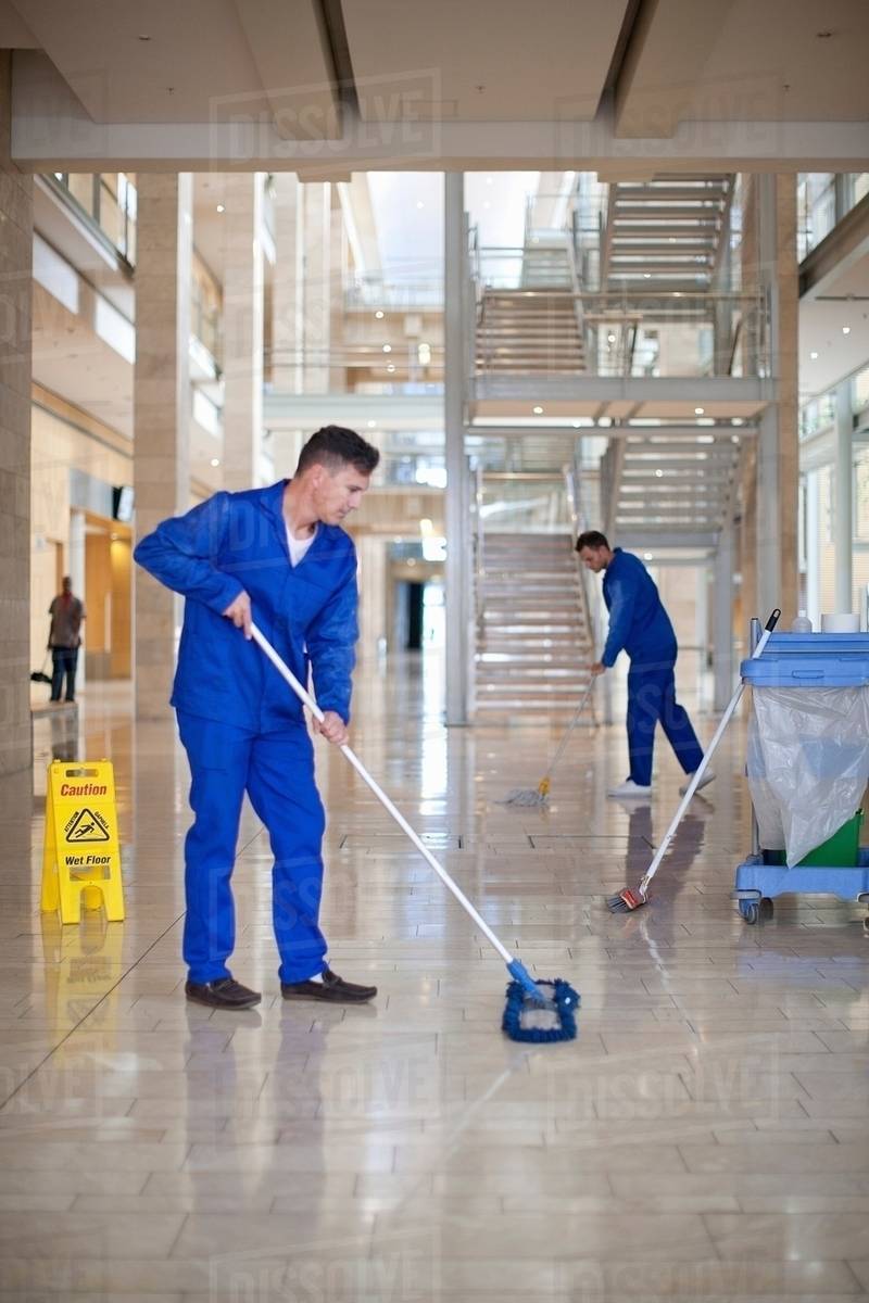 Male cleaners mopping in office atrium - Royalty-free Stock Photo ...