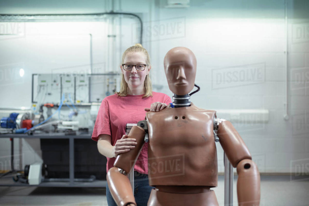 A female student standing behind a test dummy in a workshop. - Royalty ...