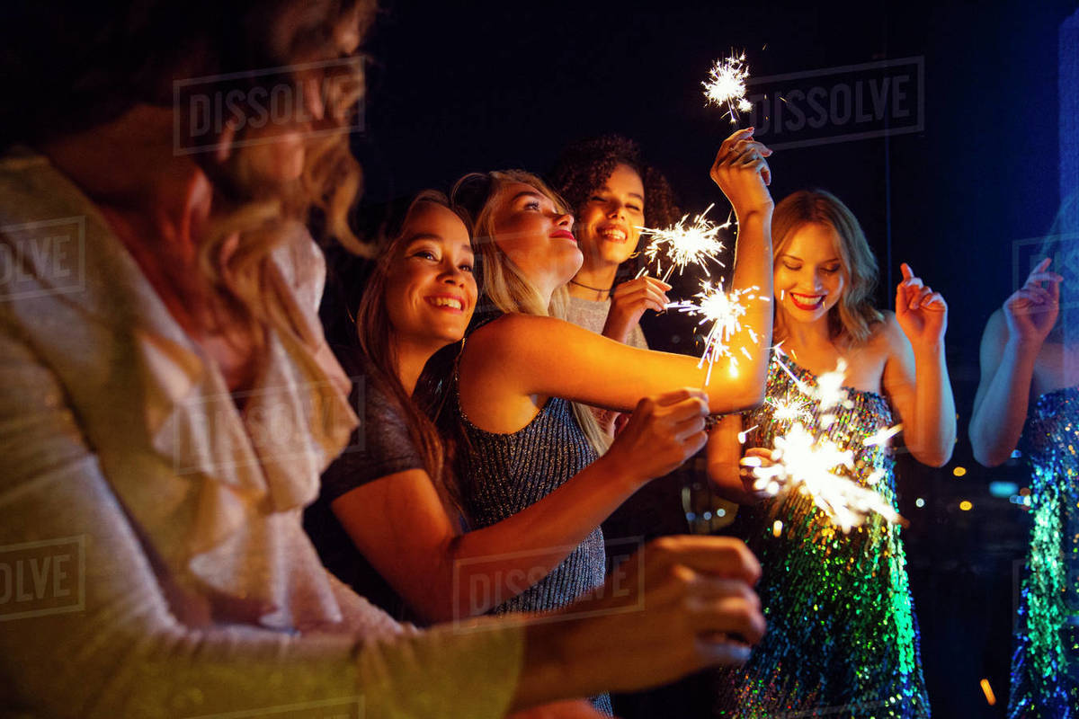 Five women dressed to go out for the evening standing outside with ...