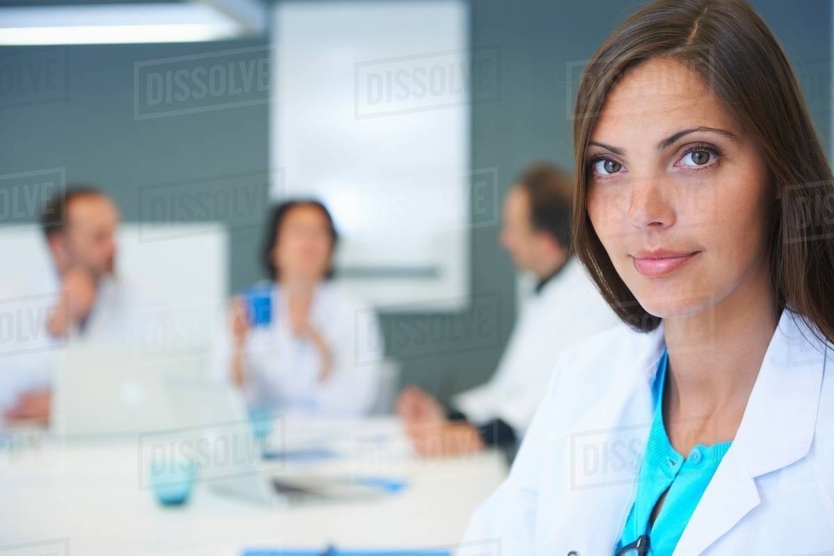 Portrait of female doctor, colleagues having discussion behind - Stock ...