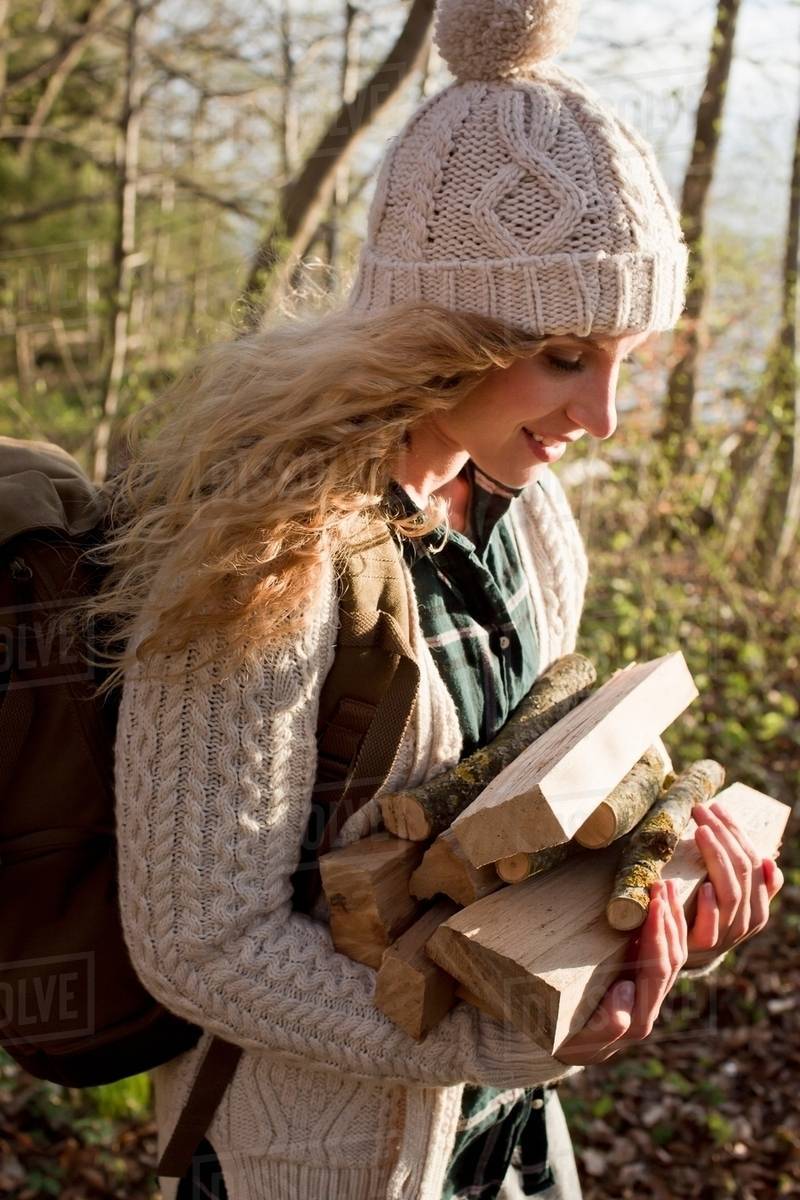Woman collecting wood for fire by seaside - Stock Photo - Dissolve