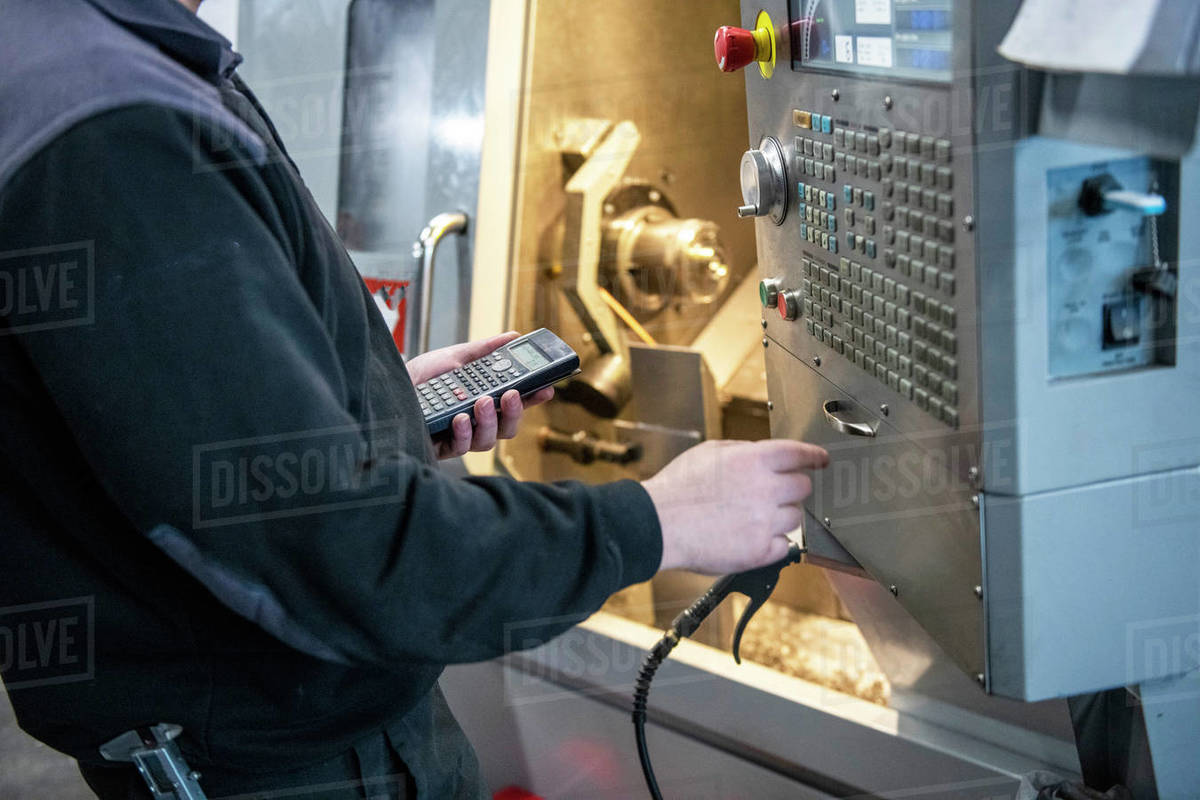 Young mechanical engineer working on steel machinery in a factory ...