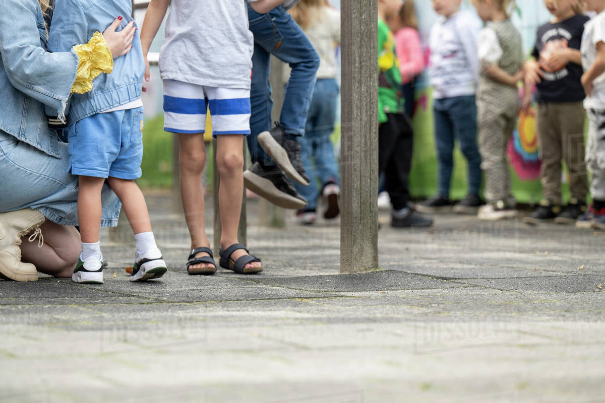 A line of diverse children captured at ground level in a park, with an ...