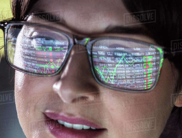A focused individual wearing glasses with computer code reflection in ...