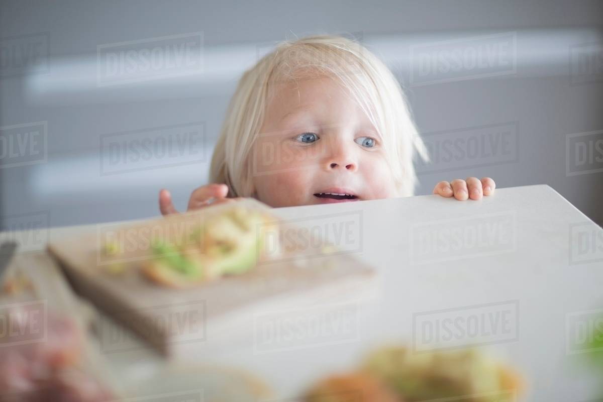 Boy peeking over kitchen counter - Royalty-free Stock Photo | Dissolve
