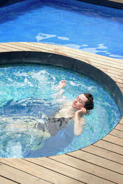 A person is sitting at a wooden table on the beach, holding a colorful ...
