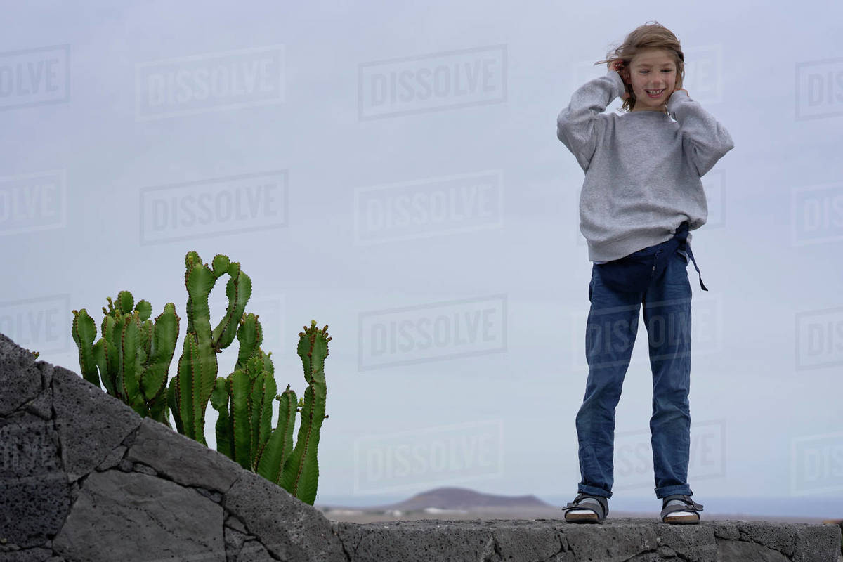 Young child adventuring atop a hill with a picturesque valley backdrop ...