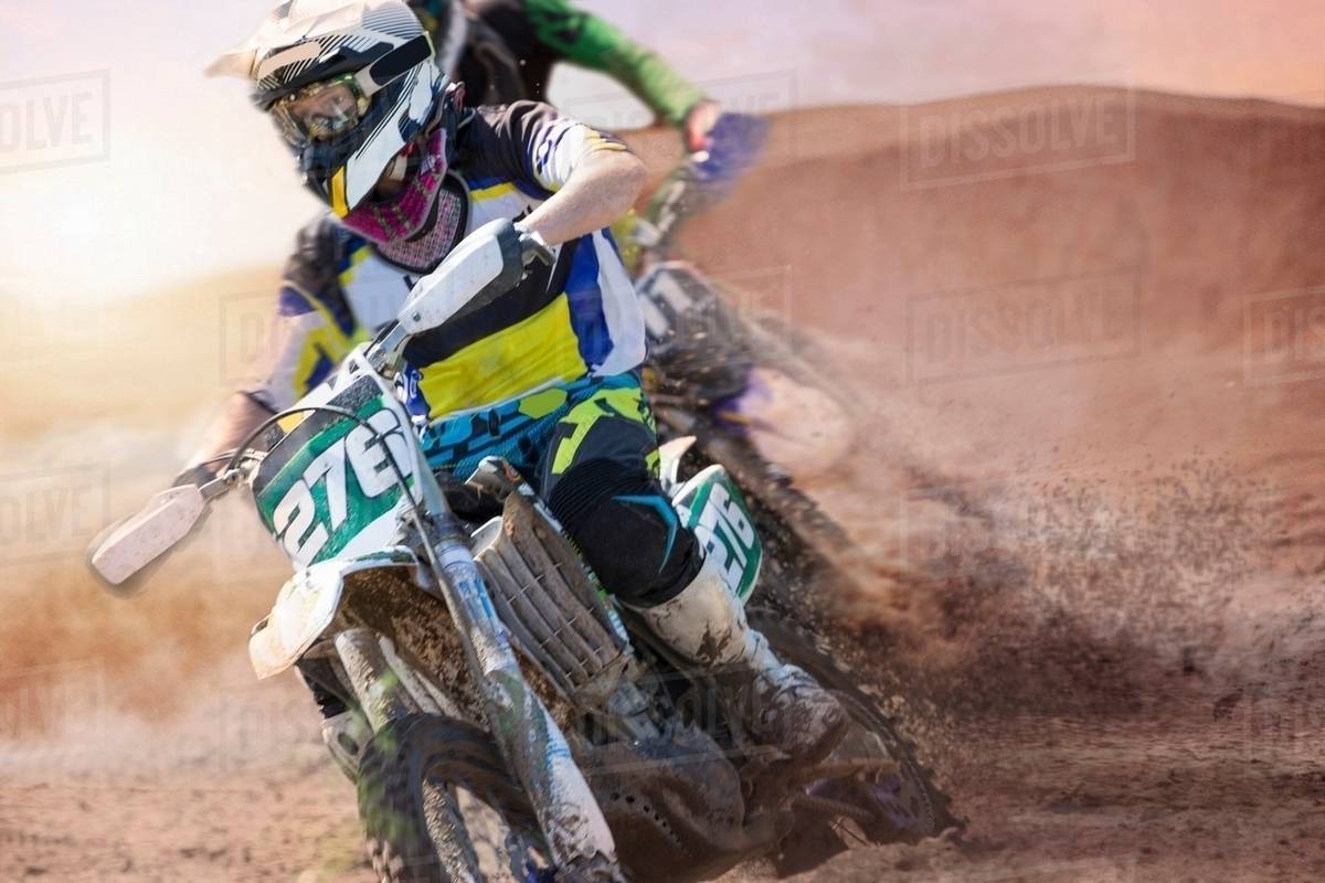 Two young male motocross riders racing on muddy track - Royalty-free ...