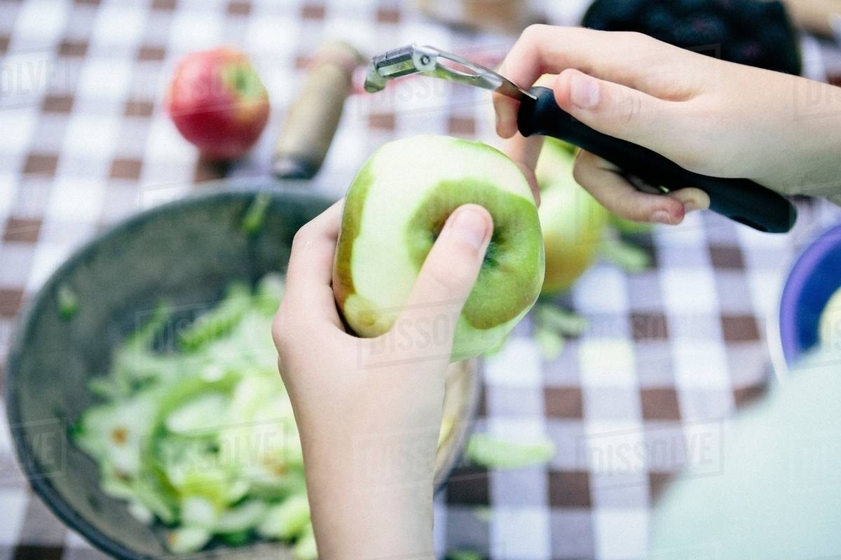 Person peeling apple - Royalty-free Stock Photo | Dissolve
