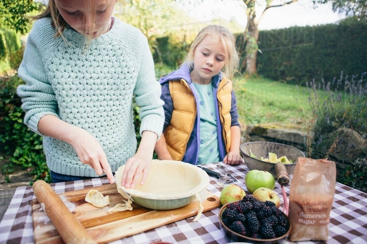 Two girls making a pie - Royalty-free Stock Photo | Dissolve