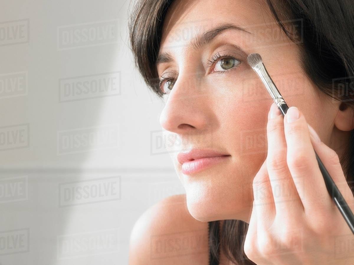 Woman putting on make up - Stock Photo - Dissolve