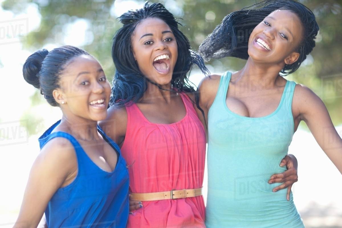 Smiling women hugging outdoors - Royalty-free Stock Photo | Dissolve