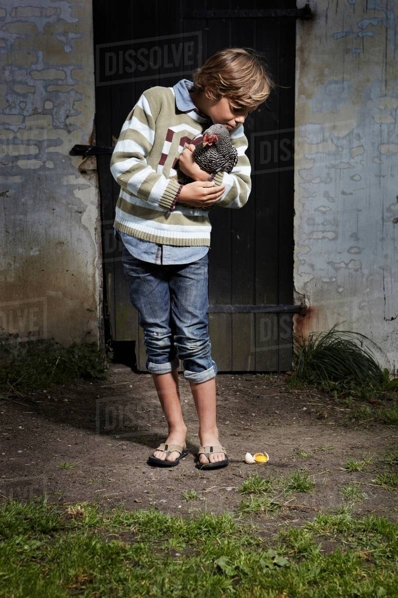 Boy holding chicken outdoors - Royalty-free Stock Photo | Dissolve