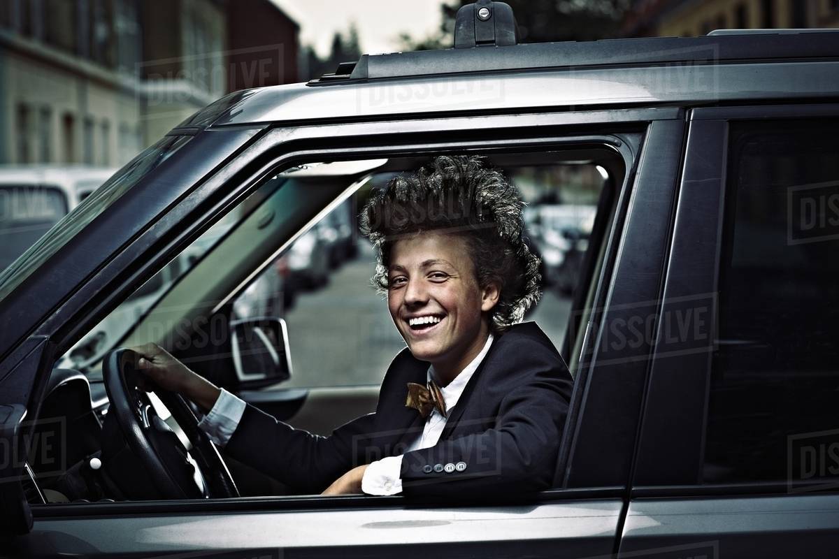 Teenage boy driving on city street - Stock Photo - Dissolve