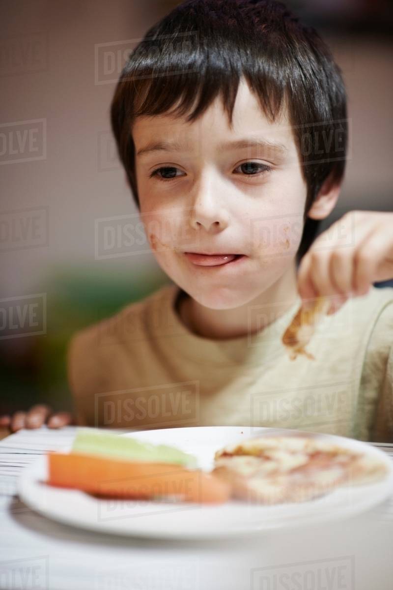 Boy eating at table - Stock Photo - Dissolve