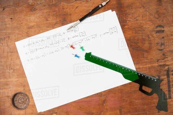 Gun shaped ruler and pen on paper - Stock Photo - Dissolve