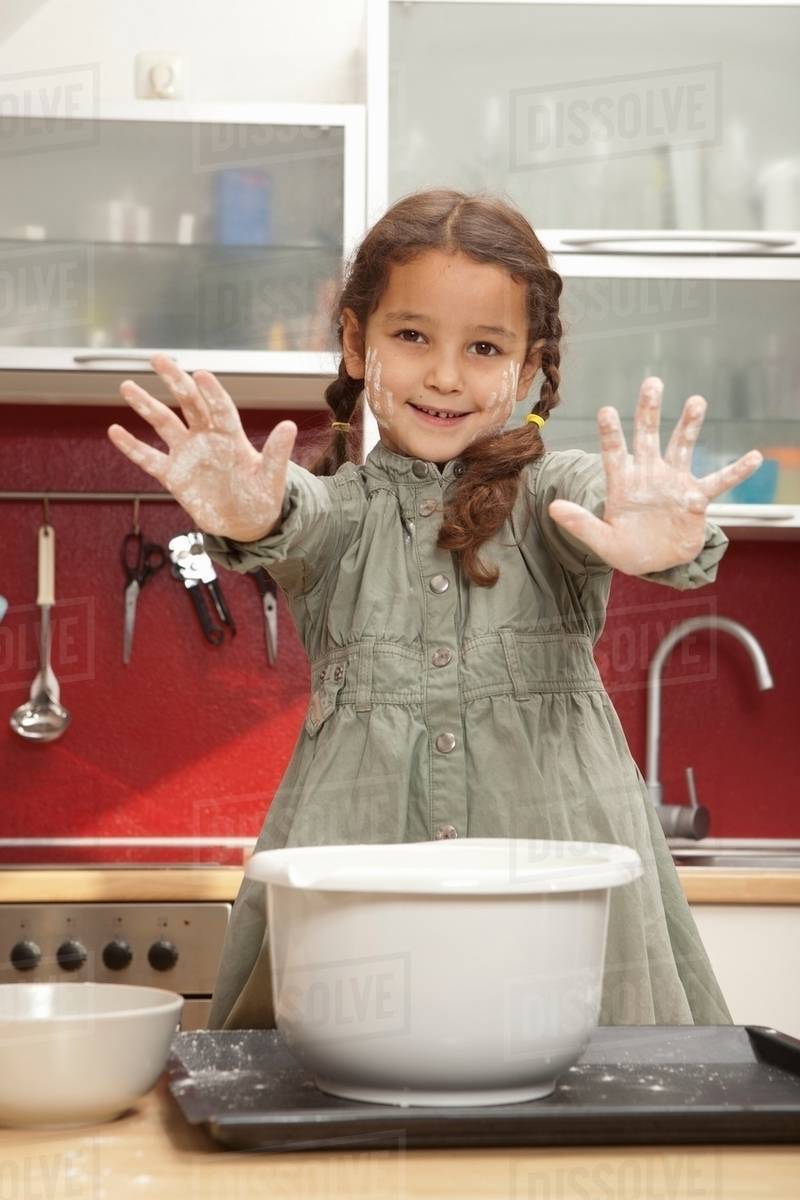 Girl with sticky hands in kitchen - Royalty-free Stock Photo | Dissolve