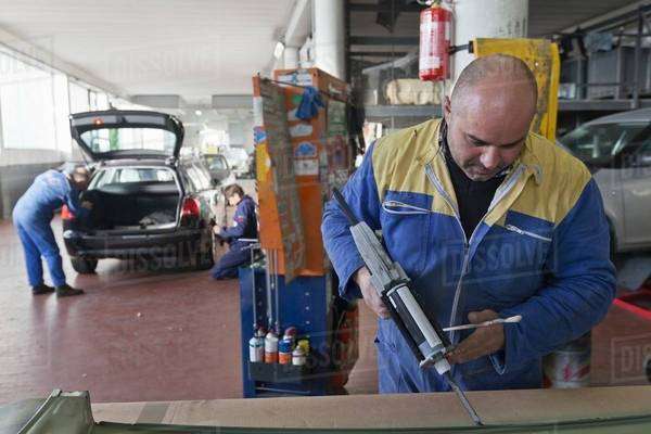 Mechanics working in garage - Stock Photo - Dissolve