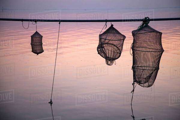 Silhouette of fishing nets over still water - Royalty-free Stock Photo ...