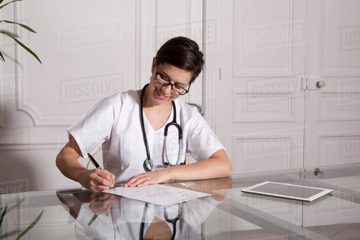 Doctor taking notes in office - Royalty-free Stock Photo | Dissolve