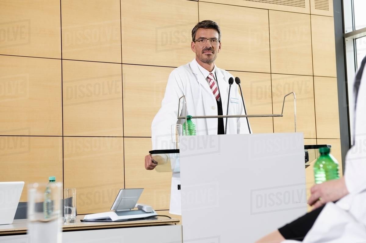 Doctor giving talk in conference room - Stock Photo - Dissolve