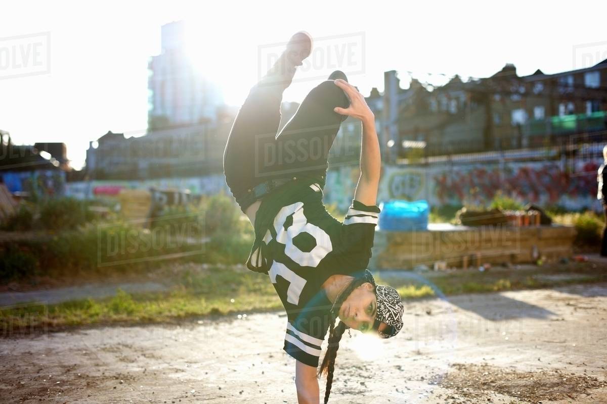 Young women doing upside down breakdancing freeze, looking at camera ...