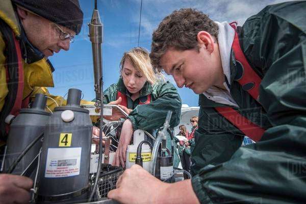 Scientists assembling sea water sampling experiment on research ship ...