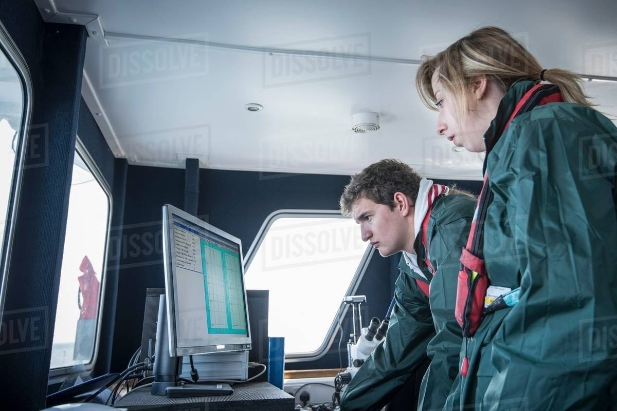Scientists inspecting data on research ship - Stock Photo - Dissolve