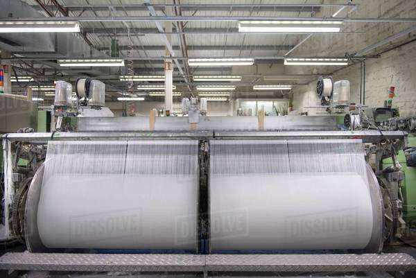 Thread on industrial loom in textile mill - Stock Photo - Dissolve
