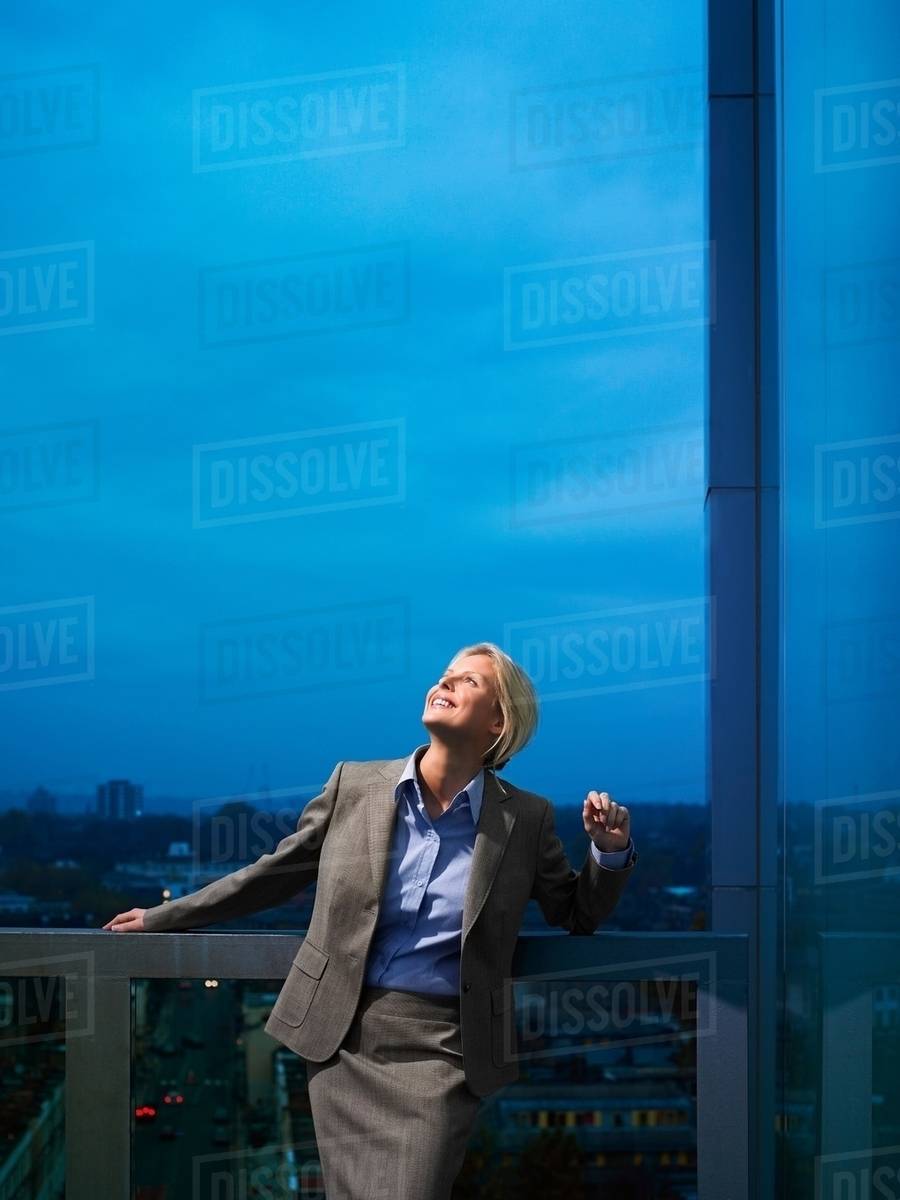 Smart lady in corporate environment overlooking the city - Royalty-free ...