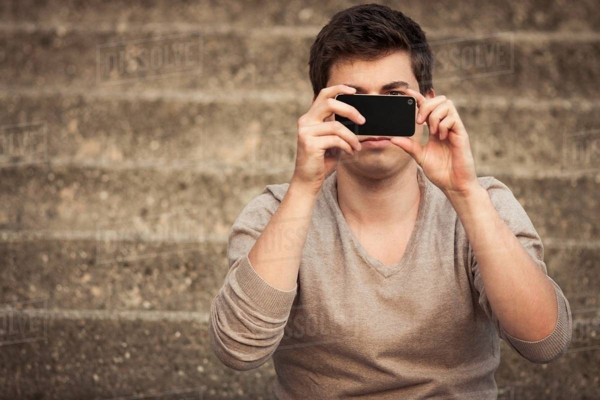 Man taking picture with cell phone - Stock Photo - Dissolve