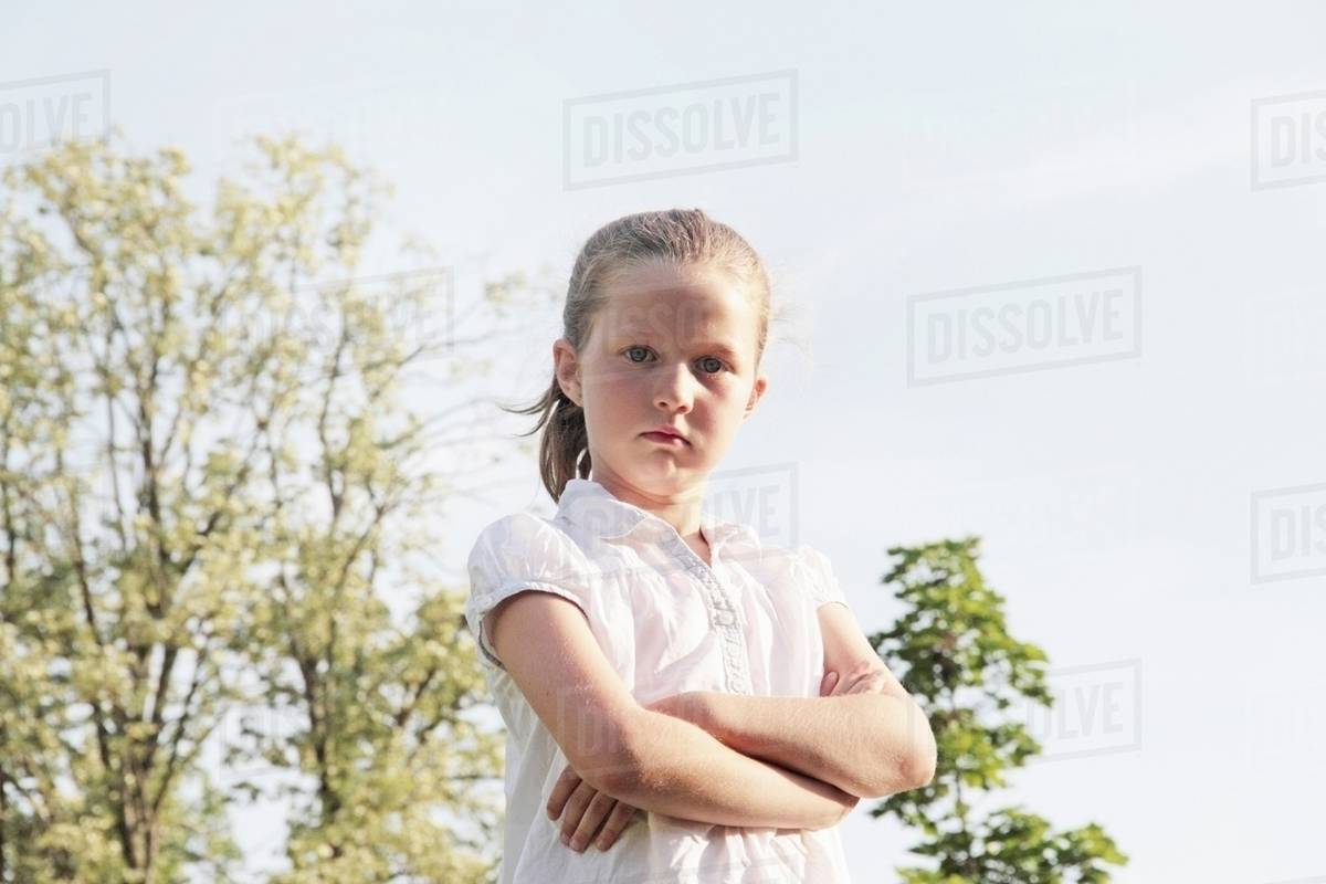 Girl standing with arms crossed outdoors - Royalty-free Stock Photo ...
