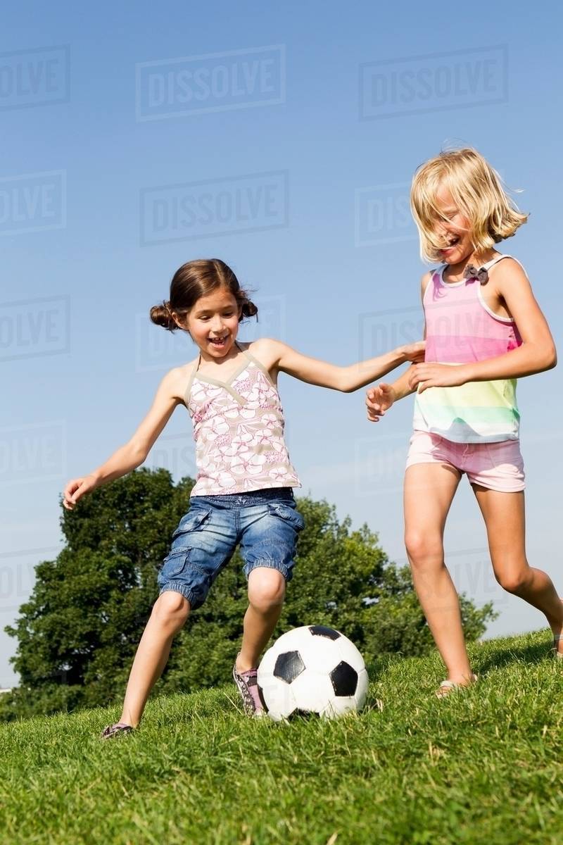 Girls playing soccer in field - Royalty-free Stock Photo | Dissolve
