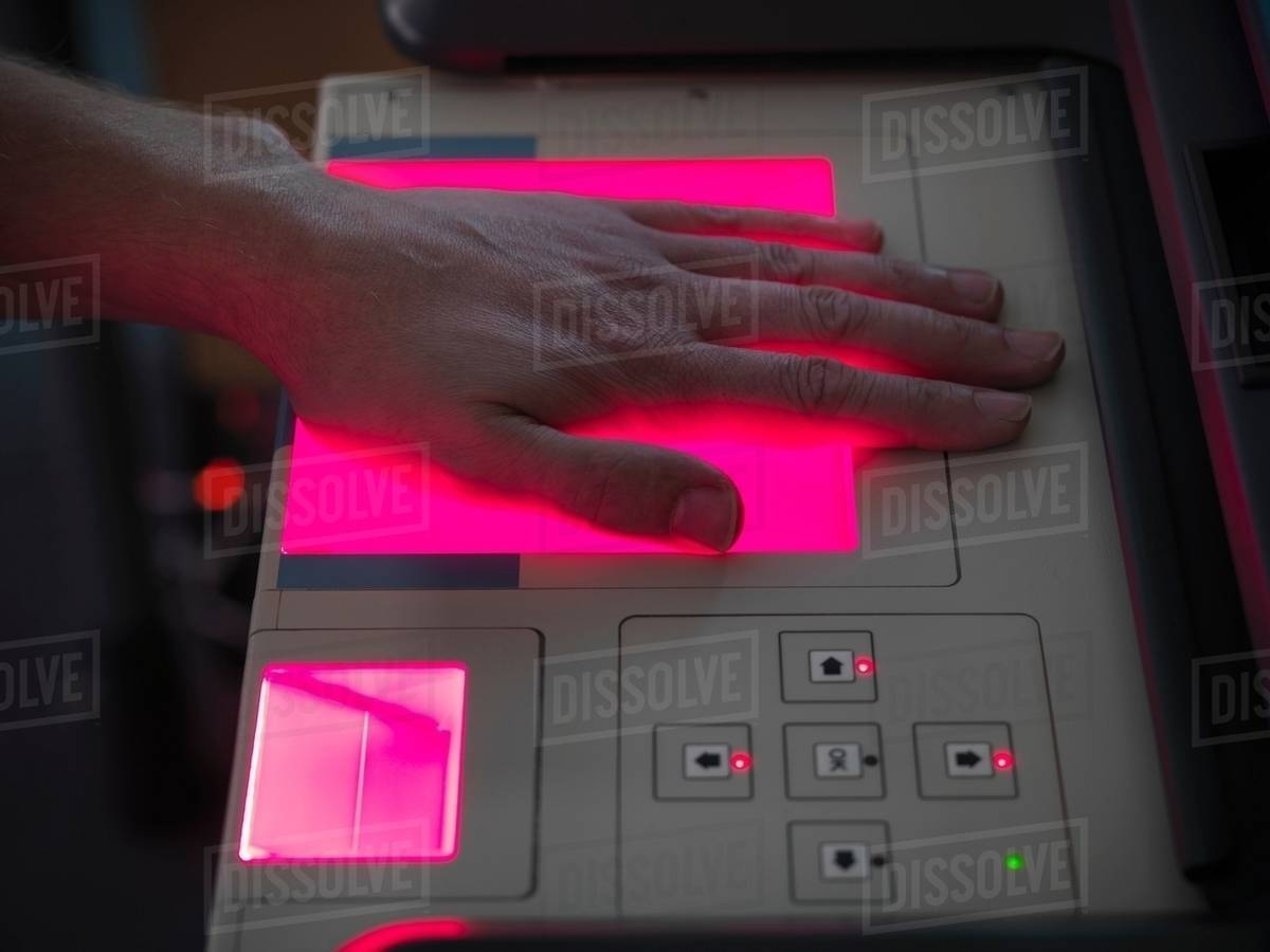 Close up up man scanning hand for fingerprints on machine in laboratory ...