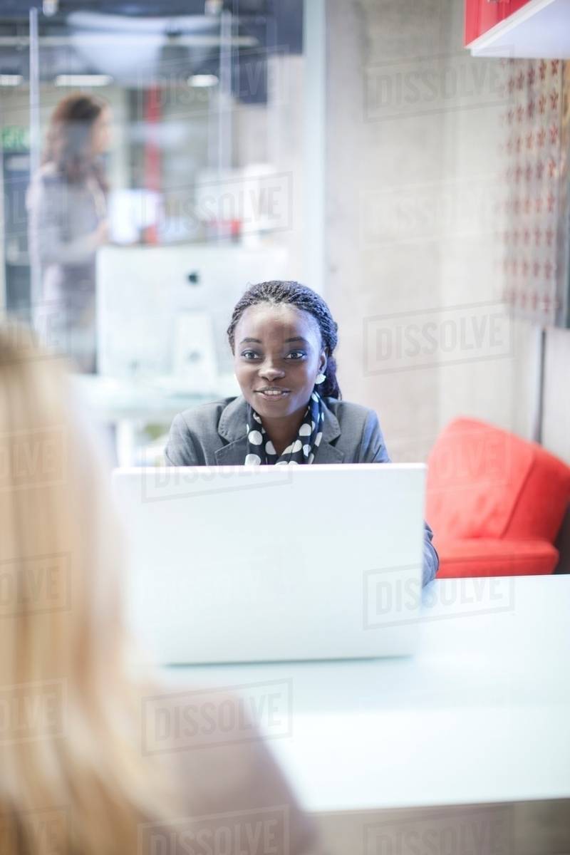 Office workers chatting at desk - Royalty-free Stock Photo | Dissolve