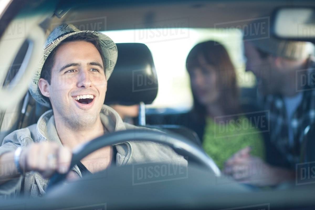 Young adult friends driving in car - Royalty-free Stock Photo | Dissolve