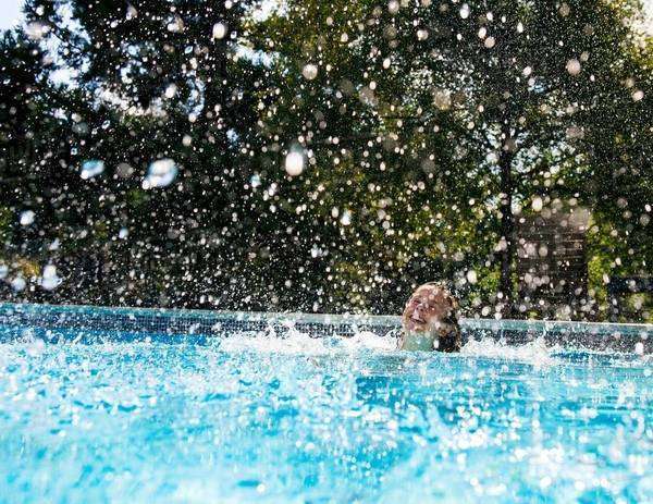 Girl splashing in swimming pool - Stock Photo - Dissolve