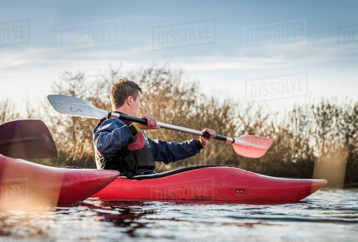 Young man kayaking - Stock Photo - Dissolve