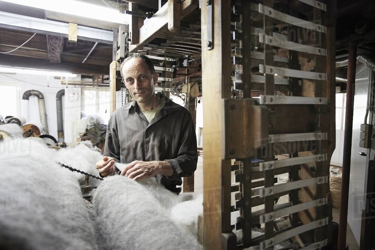 Worker with fleece in wool factory - Royalty-free Stock Photo | Dissolve