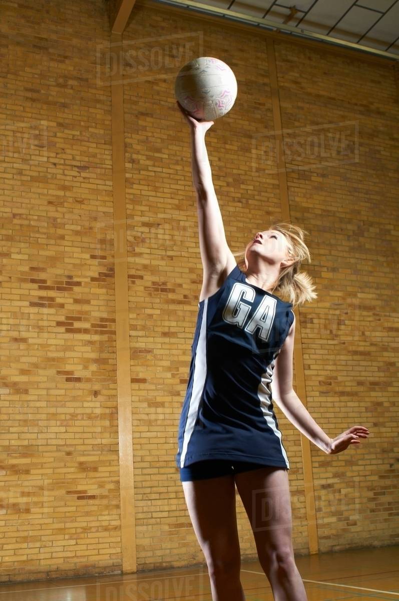 Portrait of netball player reaching for ball - Royalty-free Stock Photo ...