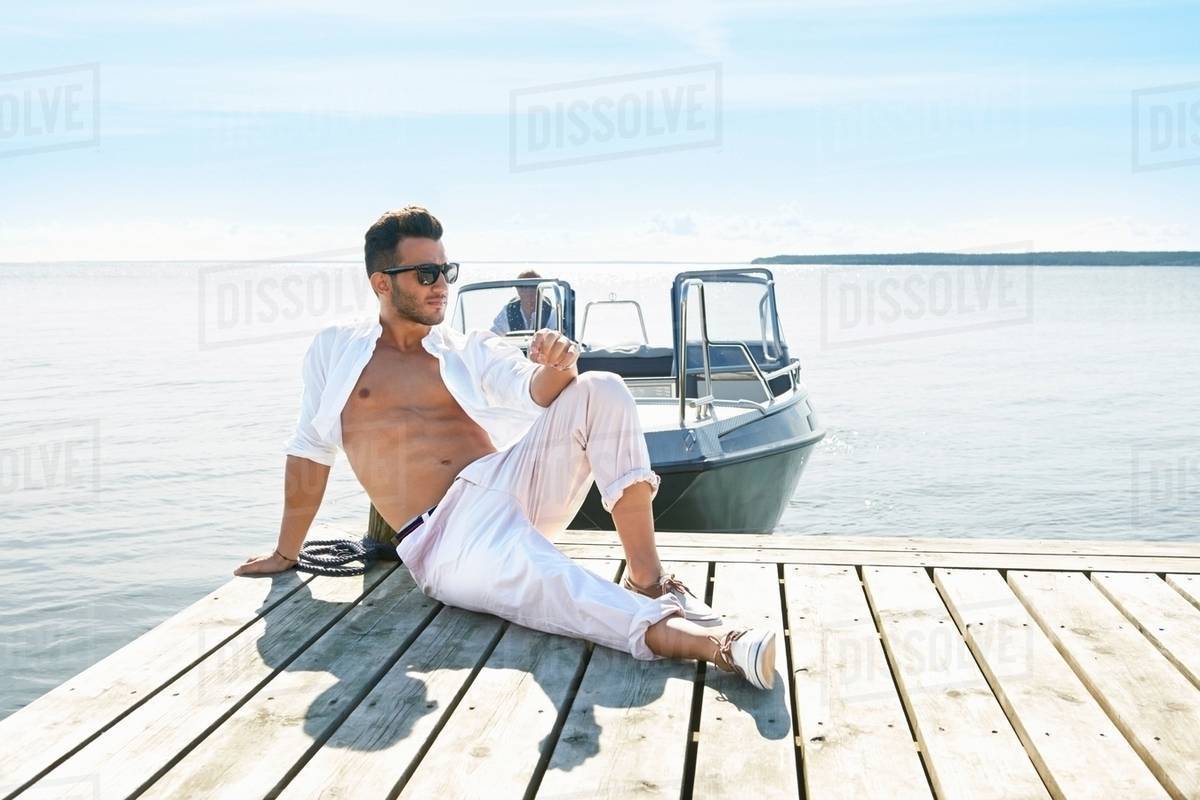 Young man sitting on pier, Gavle, Sweden - Royalty-free Stock Photo ...