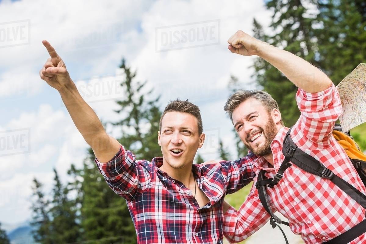 Two male friends pointing and cheering - Stock Photo - Dissolve