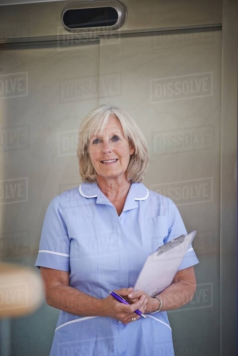 Portrait of mature female nurse in hospital corridor - Royalty-free ...