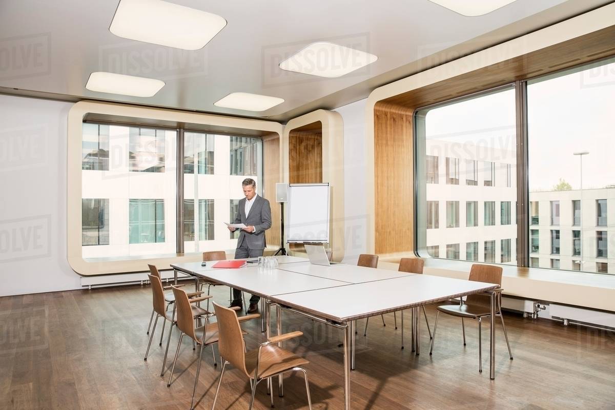 Businessman standing in conference room - Stock Photo - Dissolve
