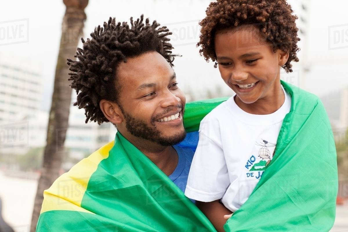 Father and son wrapped in Brazilian flag on Ipanema beach, Rio De ...
