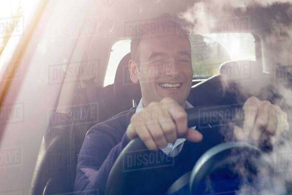 Happy man behind wheel of car - Stock Photo - Dissolve